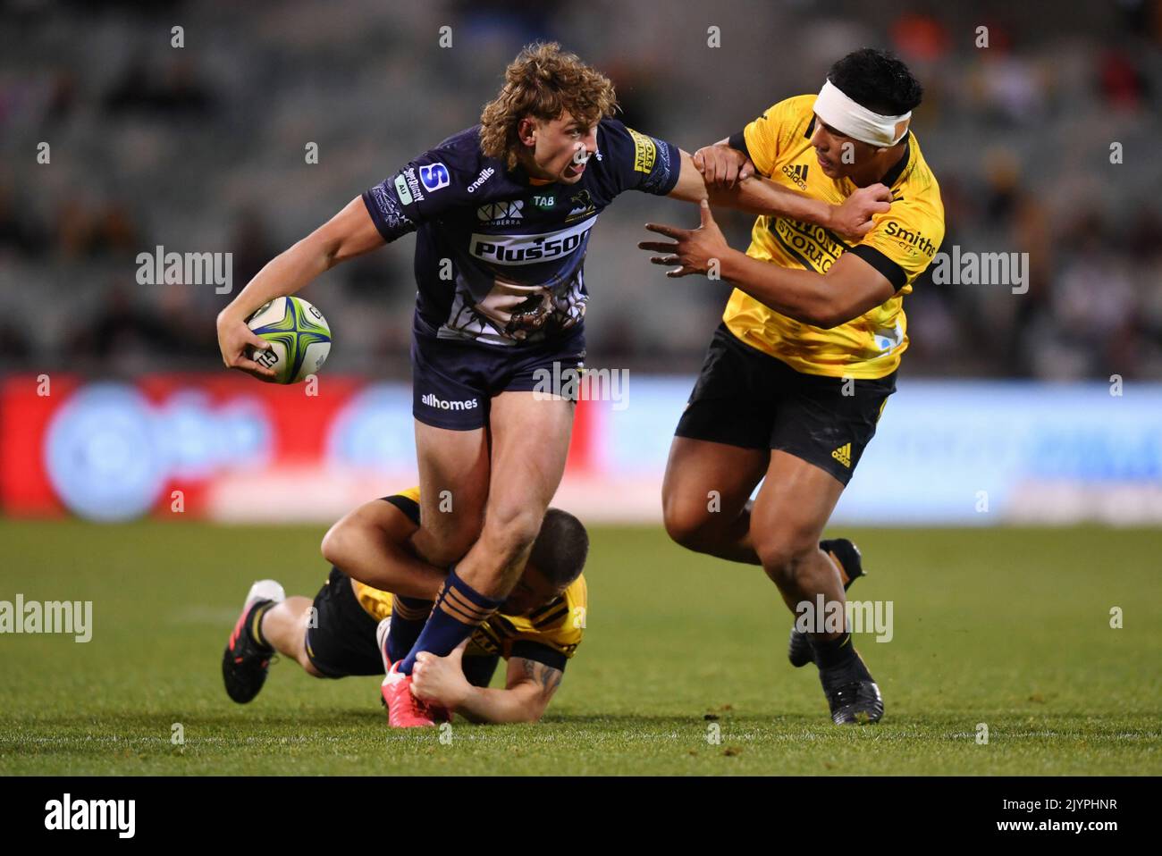 Bayley Kuenzle of the Brumbies (left) is tackled by Xavier Numia of the ...