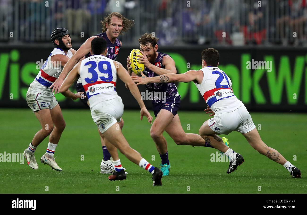 Darcy Tucker of the Dockers is tackled by Tom Liberatore and Jason ...