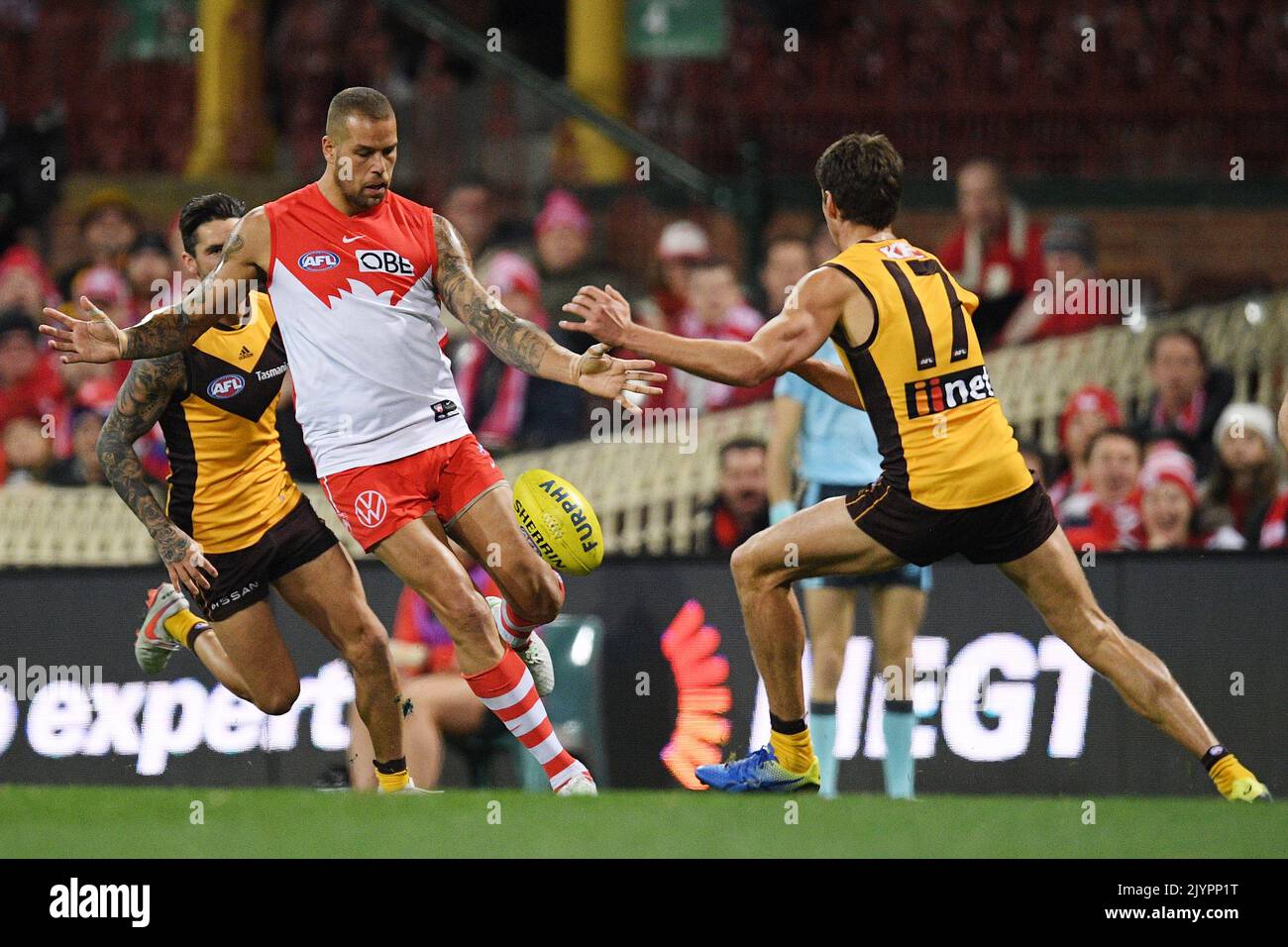 Lance Franklin of the Swans gets a kick past Daniel Howe of the Hawks ...