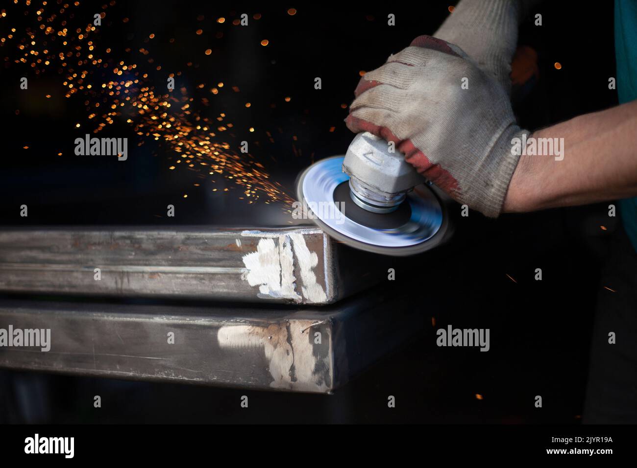 Metal processing. Grinder in hand. Worker holds tool. Creation of steel ...