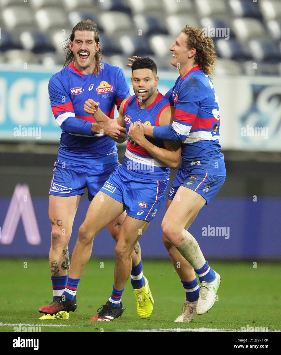 Jason Johannisen of the Bulldogs is congratulated by Josh Bruce and ...