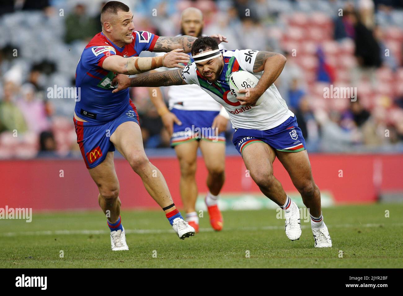Jazz Tevaga of the Warriors holds off David Klemmer during the NRL ...