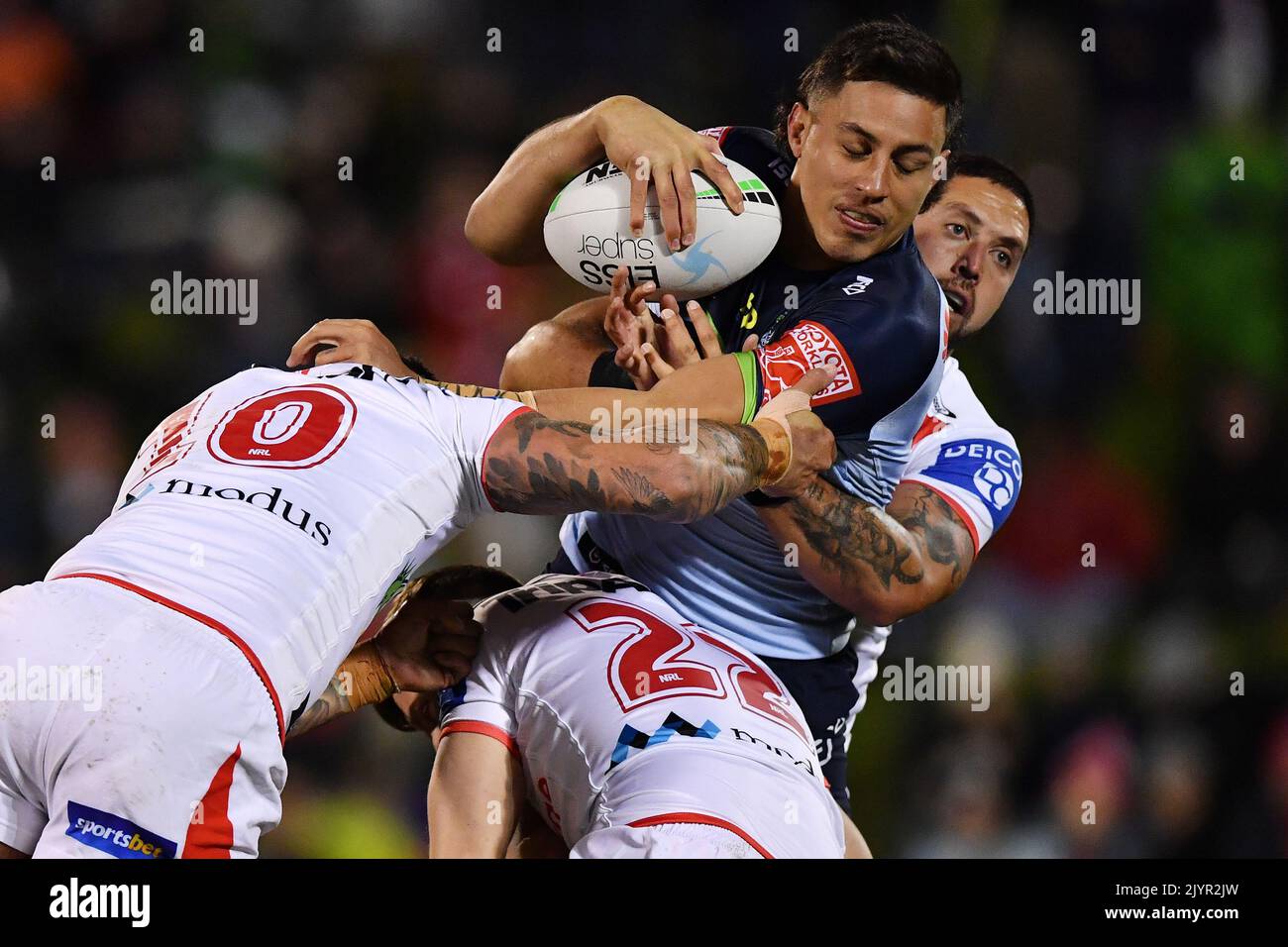 Joseph Tapine of the Raiders is tackled by Paul Vaughan and Billy Burns ...