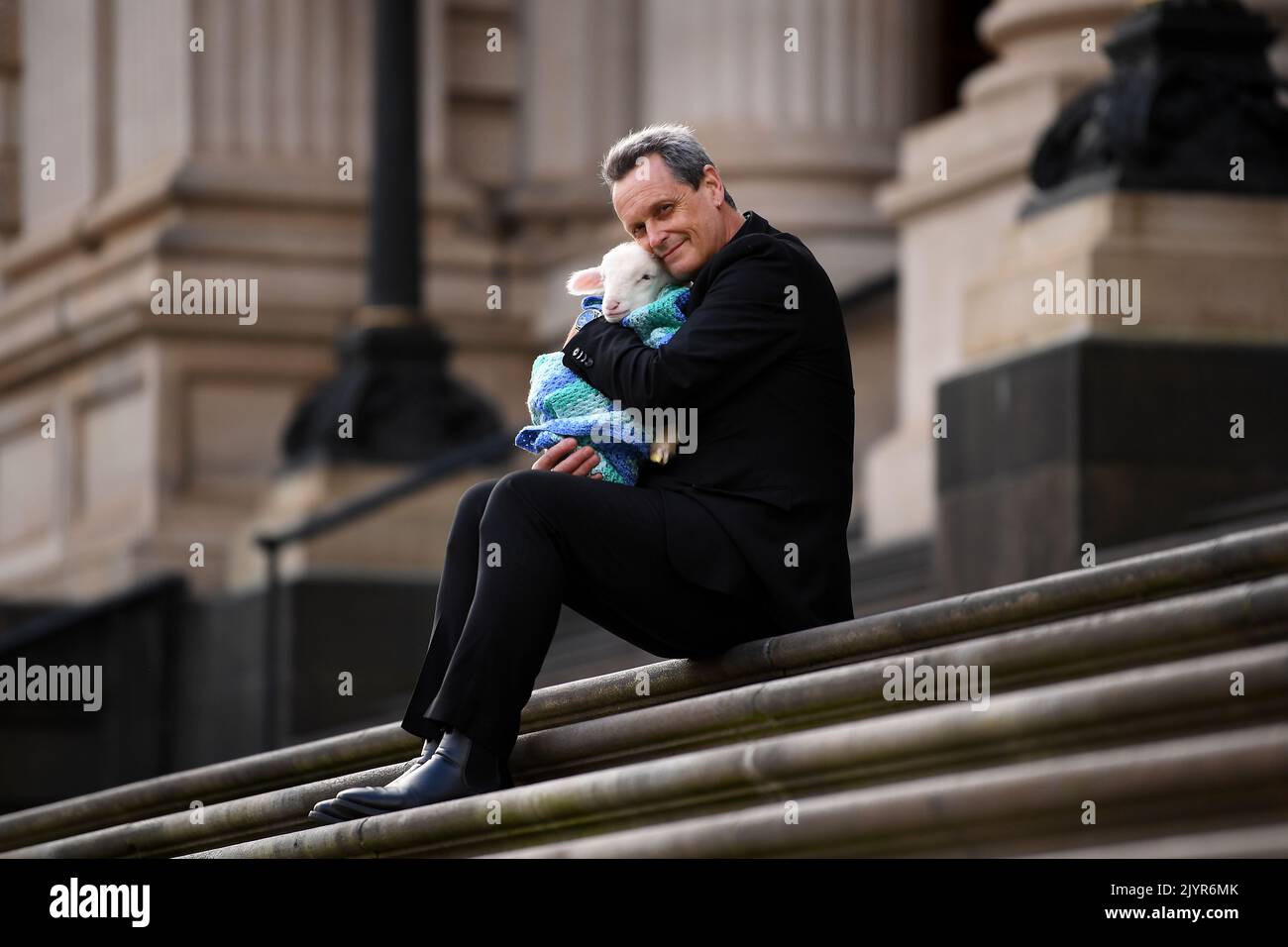 Animal Justice Party MP Andy Meddick poses for a photograph with a lamb ...