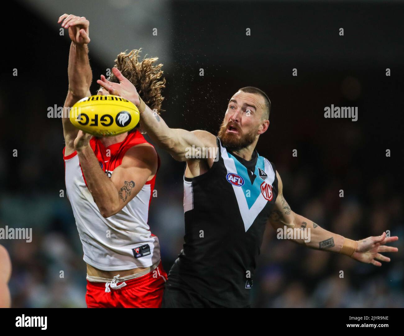 Tom Hickey of the Swans and Charlie Dixon of the Power compete in a ...