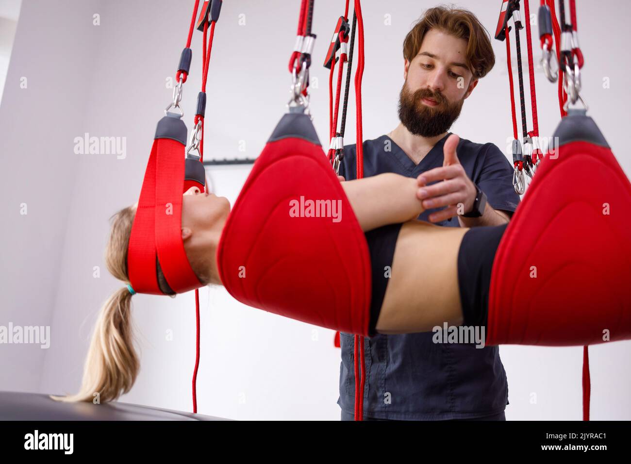 Physiotherapist assists female patient undergoing rehabilitative ...