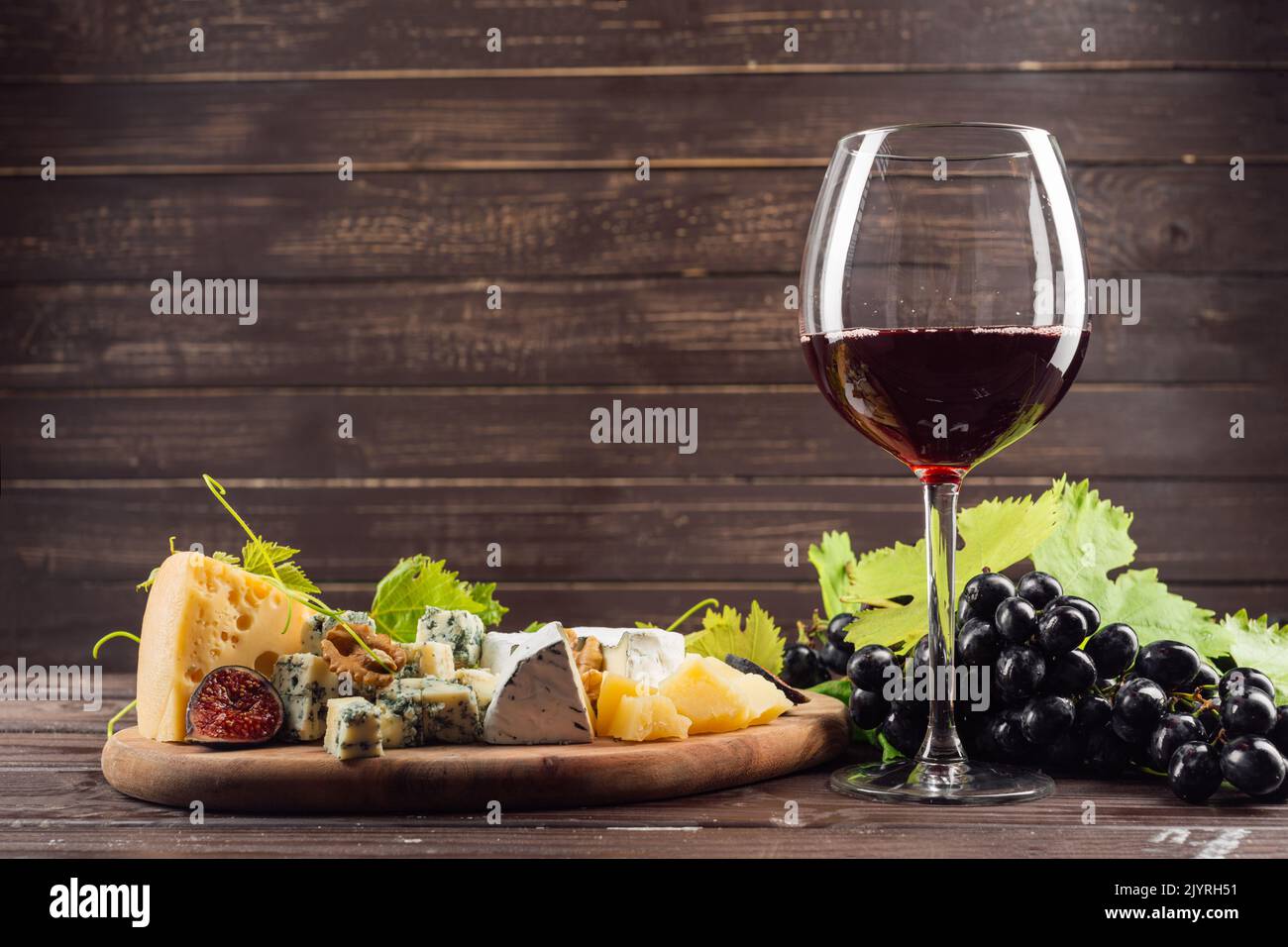wine glass and bunch of grapes on wooden table Stock Photo - Alamy