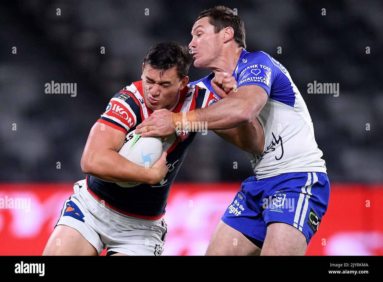 Joseph Manu of the Roosters is tackled by Josh Jackson of the Bulldogs ...