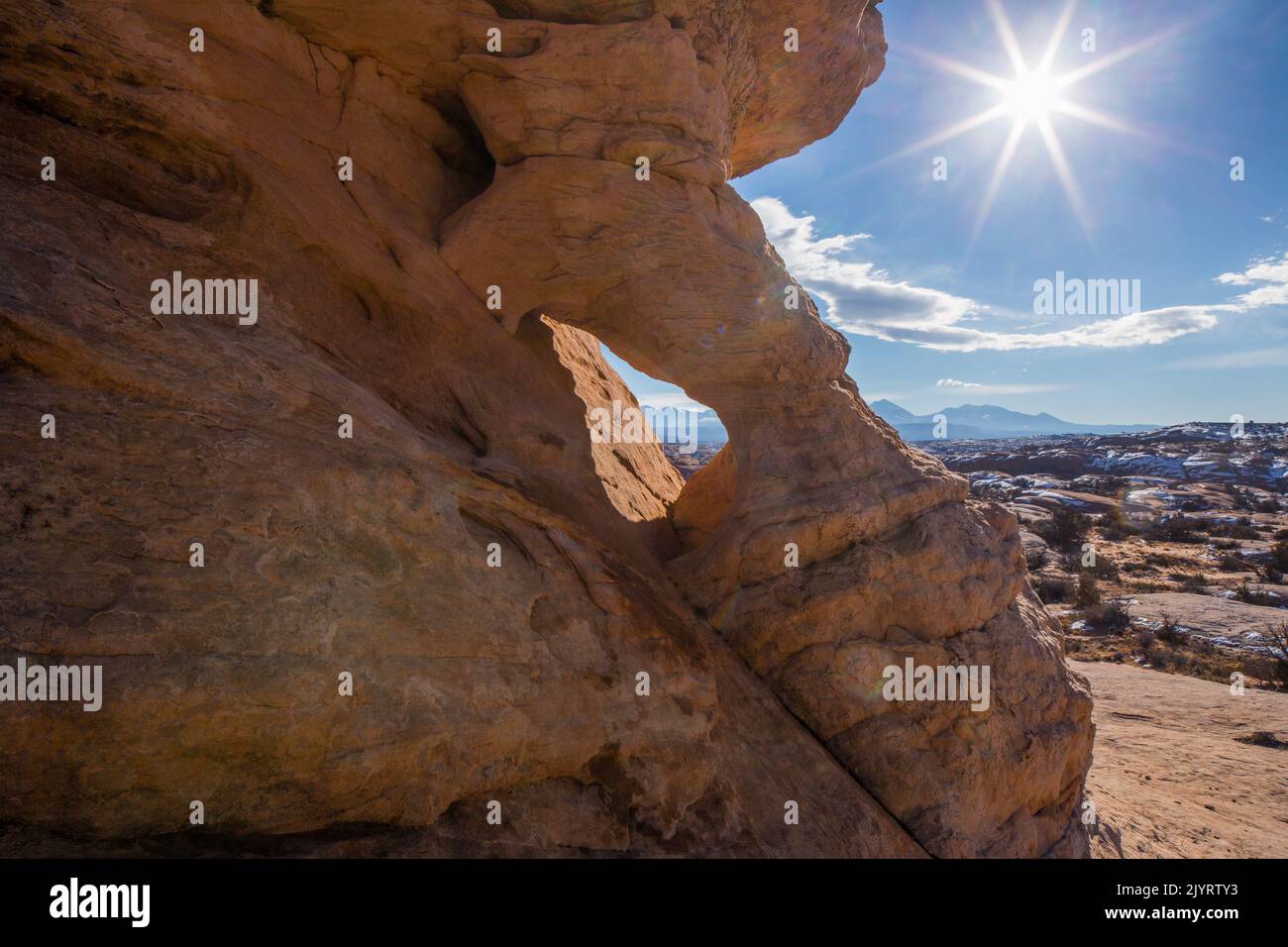 A small sandstone mini arch in Arches National Park with the La Sal ...