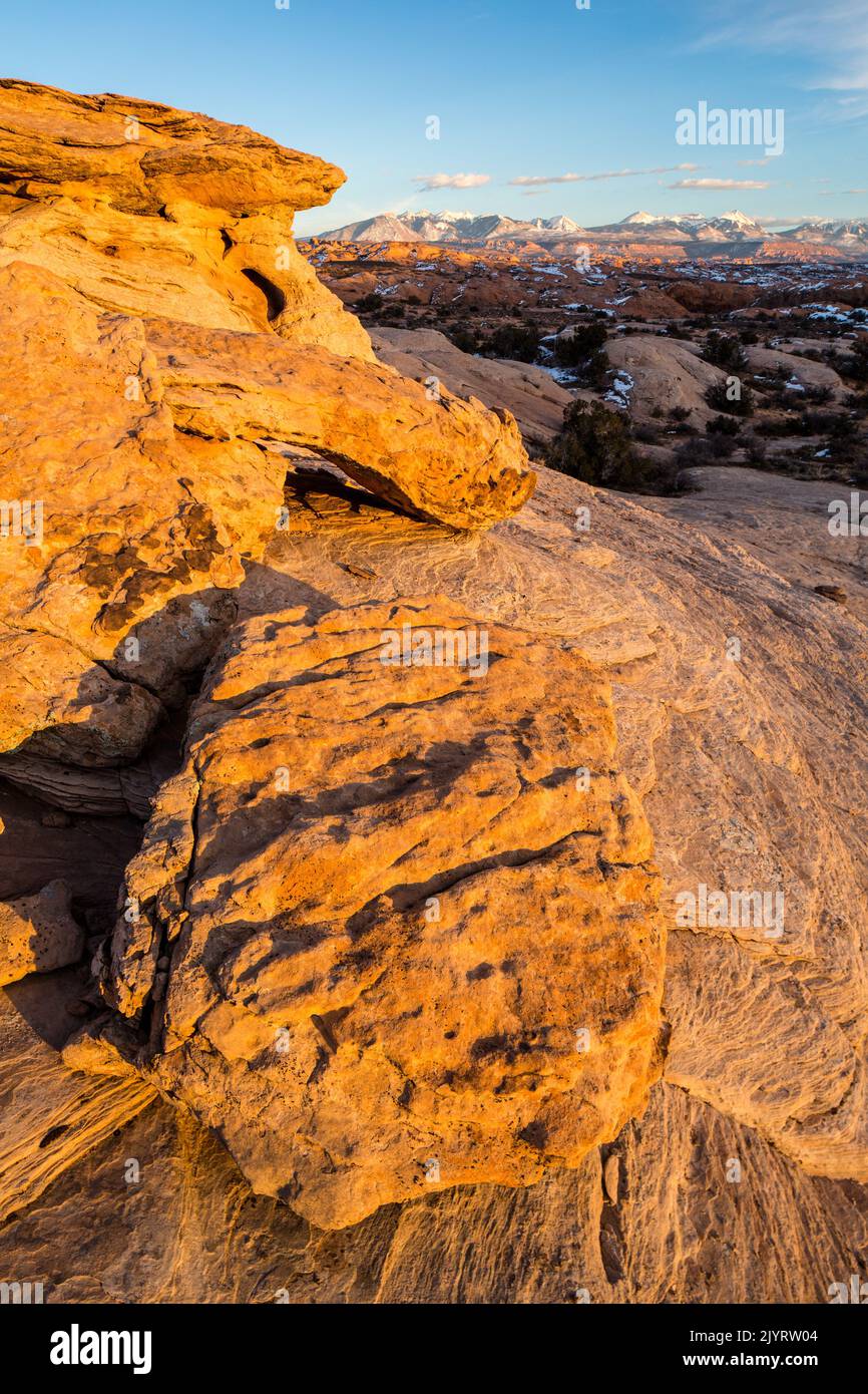 Textured Entrada sandstone in front of a small mini arch with the La ...