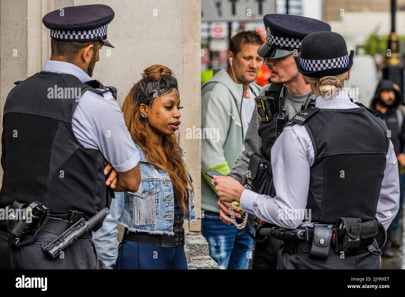 London, UK. 8th Sep, 2022. Police stop and handcuff a black woman, who ...