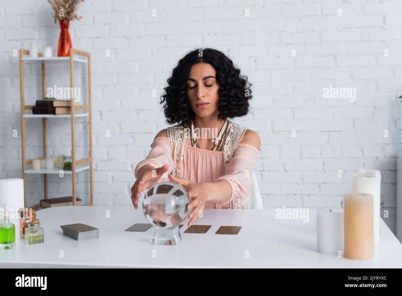 oracle with closed eyes touching crystal ball near tarot cards Stock ...