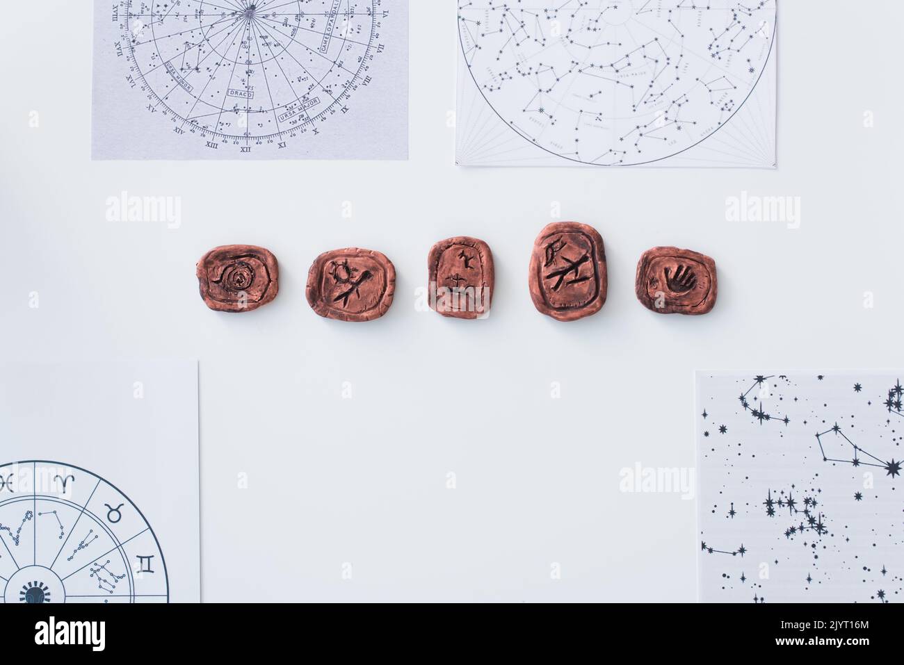 top view of celestial charts and clay runes on white table Stock Photo ...