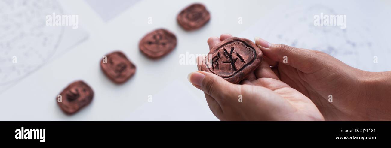partial view of cropped fortune teller holing clay rune, banner Stock ...