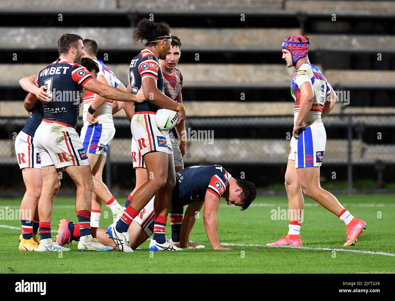 Kalyn Ponga of the Knights (right) looks on as Roosters players ...