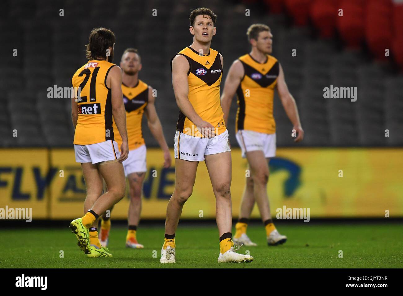 Jacob Koschitzke (centre) of Hawthorn looks dejected after being ...