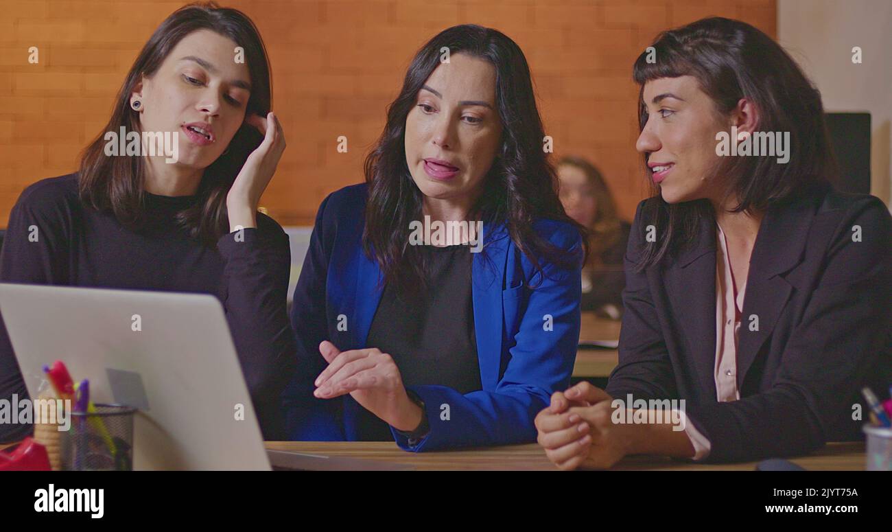 Senior female executive explaining work to young women employees ...