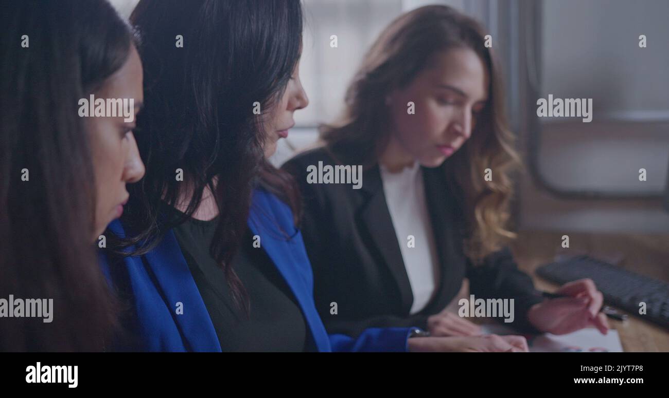 Office female leader explaining work to young employees. Businesswoman coaching work to ...