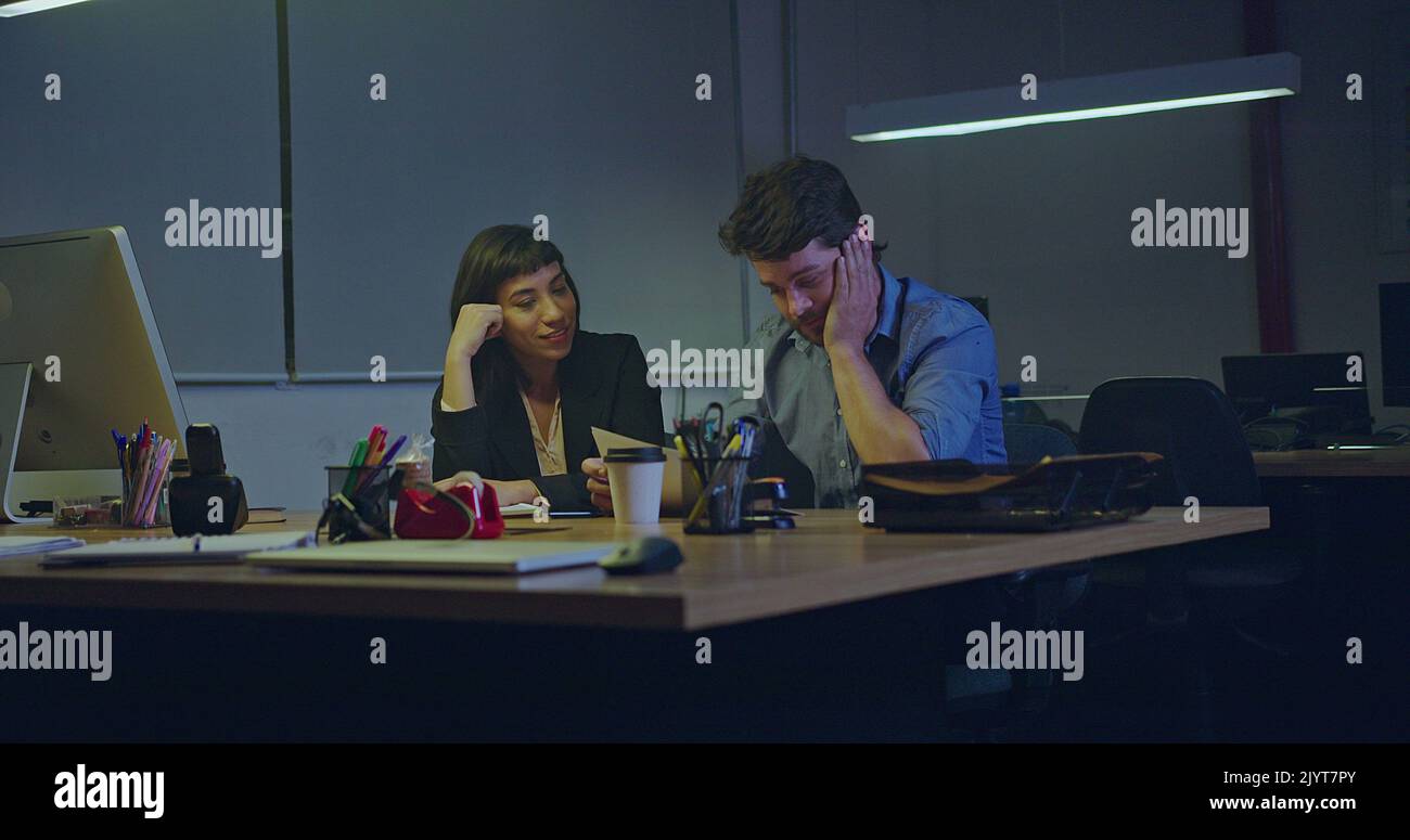Frustrated business man and woman working late at night in the office ...