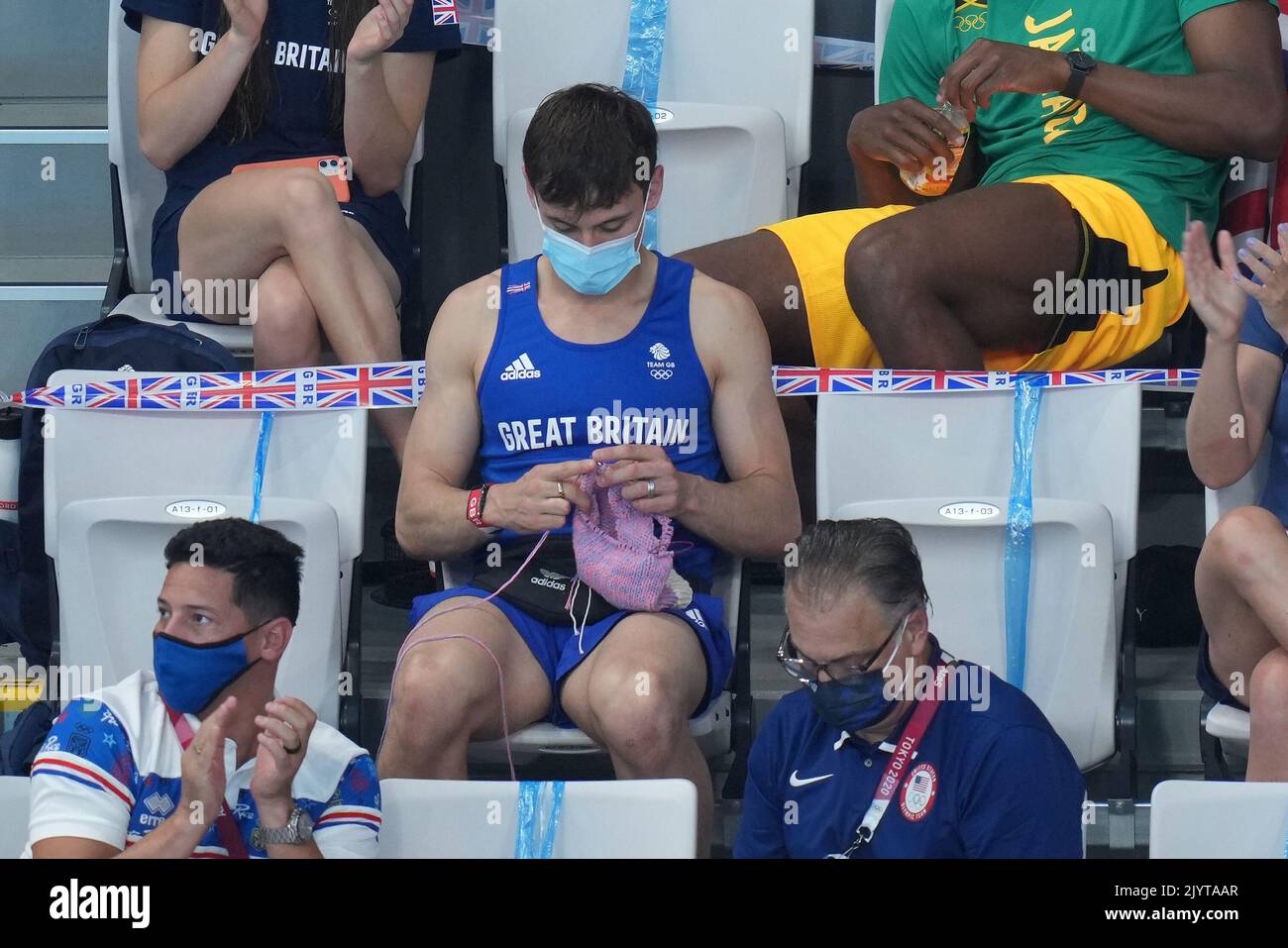 Tom Bailey of Great Britain is seen knitting as he sits in the stands during the Women's 3m ...