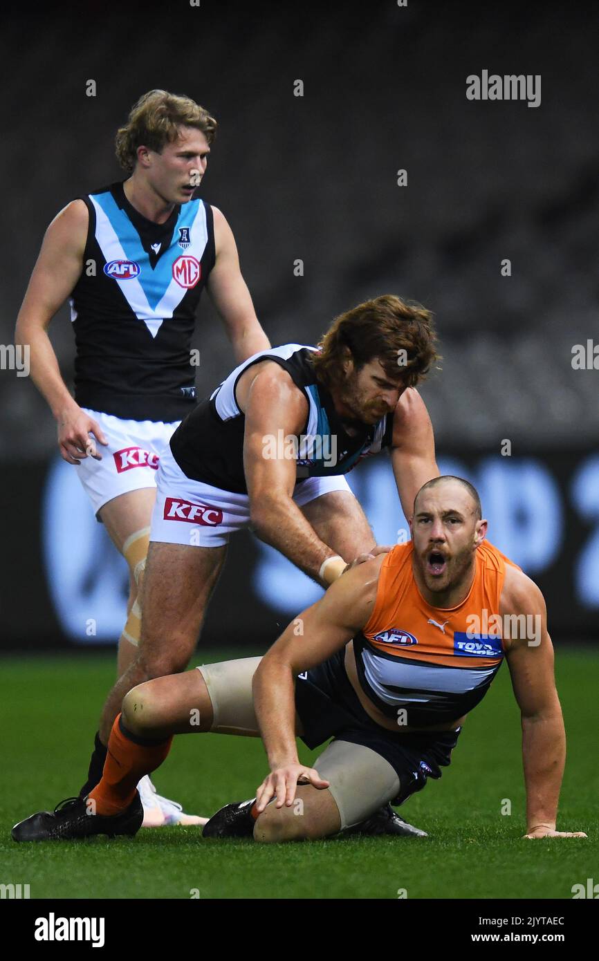 Scott Lycett of Port Adelaide (centre) pushes Shane Mumford of the ...