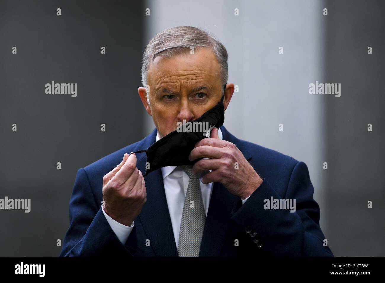 Australian Opposition leader Anthony Albanese removes his face mask ...