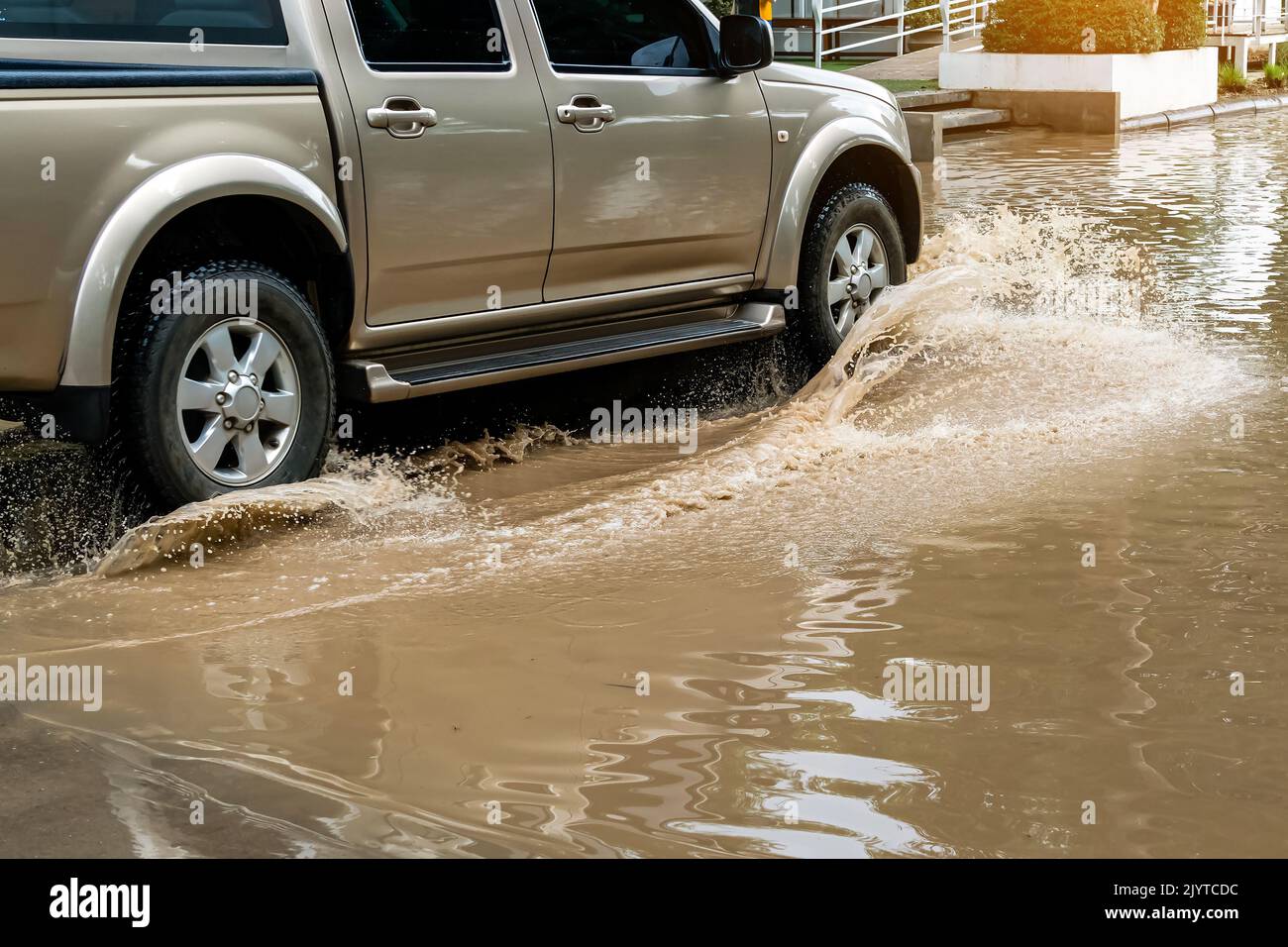 Pickup truck passing through flooded road. Driving car on flooded road ...