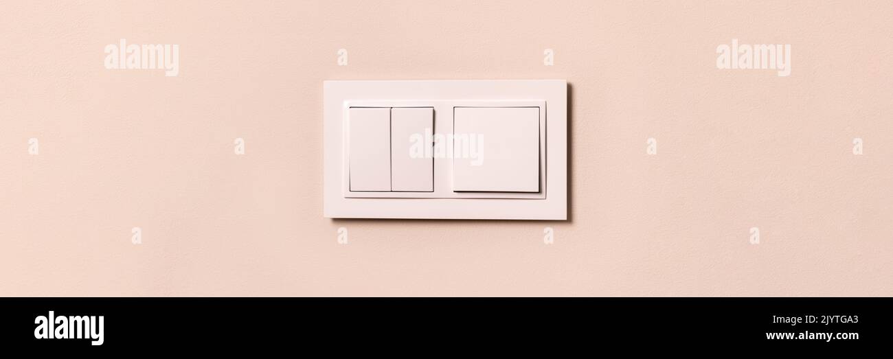 Group of white electrical switches on modern beige wall with copy space ...
