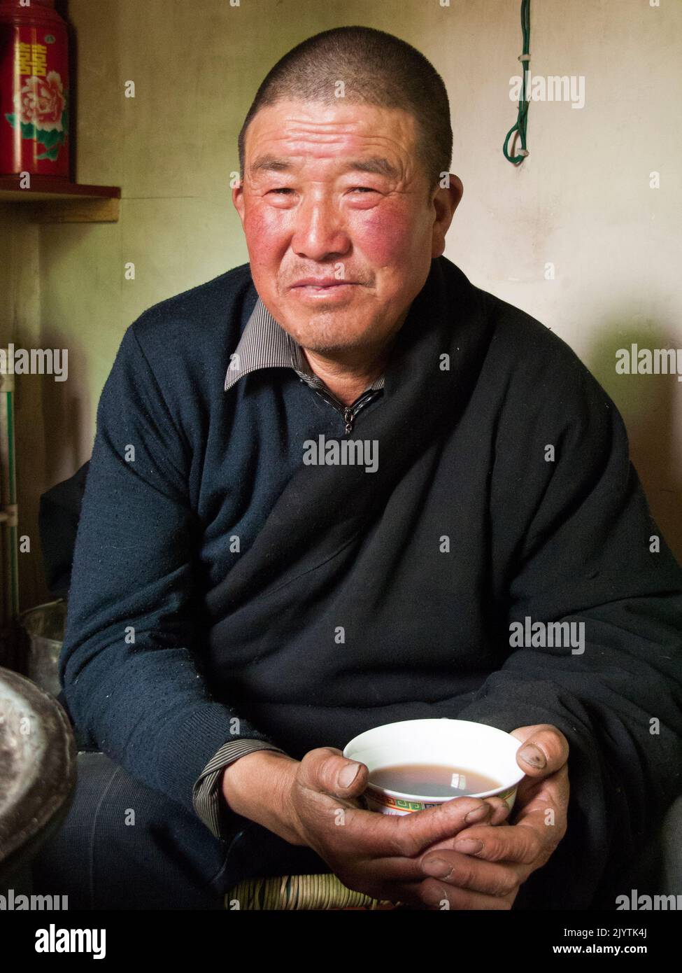 Portrait of an ethnic Tibetan man eating noodle meal prepared for a ...