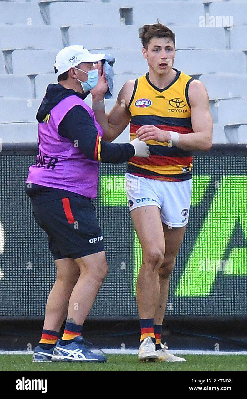 Jake Kelly of the Adelaide Crows (right) exits the field after sustains ...
