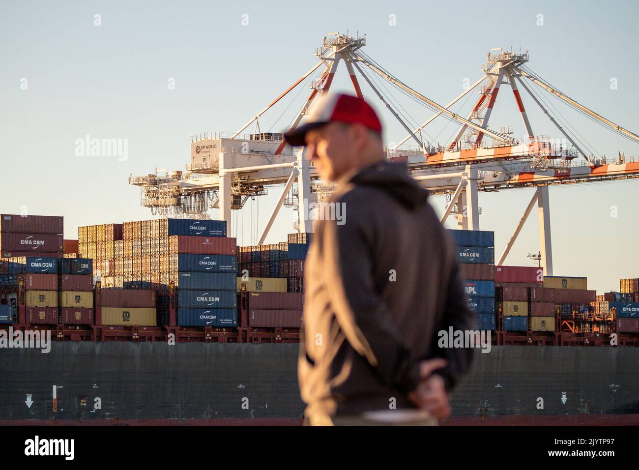 Shipping containers are seen being loaded onto a container ship at ...