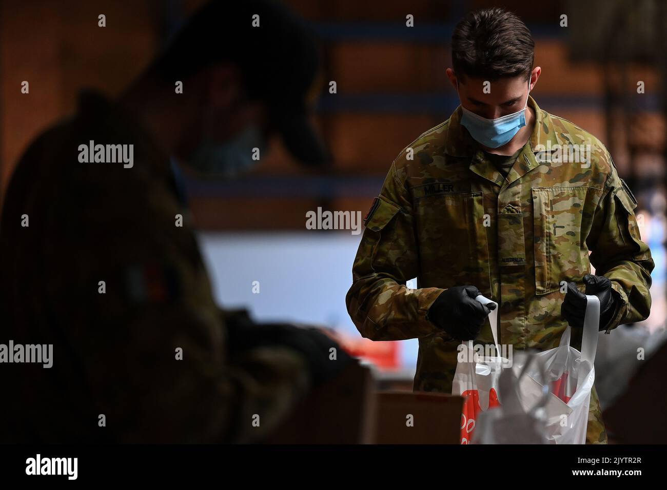 Australian Defence Force personnel (ADF) wear face masks as they pack ...