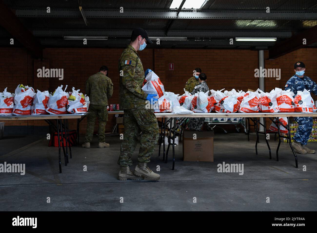 Australian Defence Force personnel (ADF) wear face masks as they pack ...