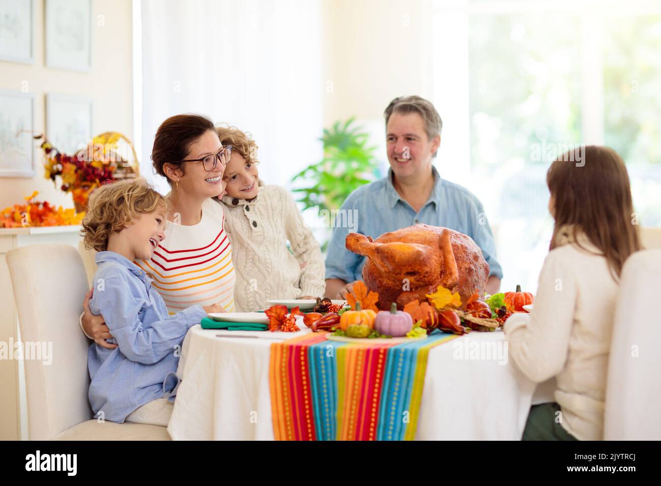 Family at Thanksgiving dinner. Parents and kids enjoy roasted turkey ...