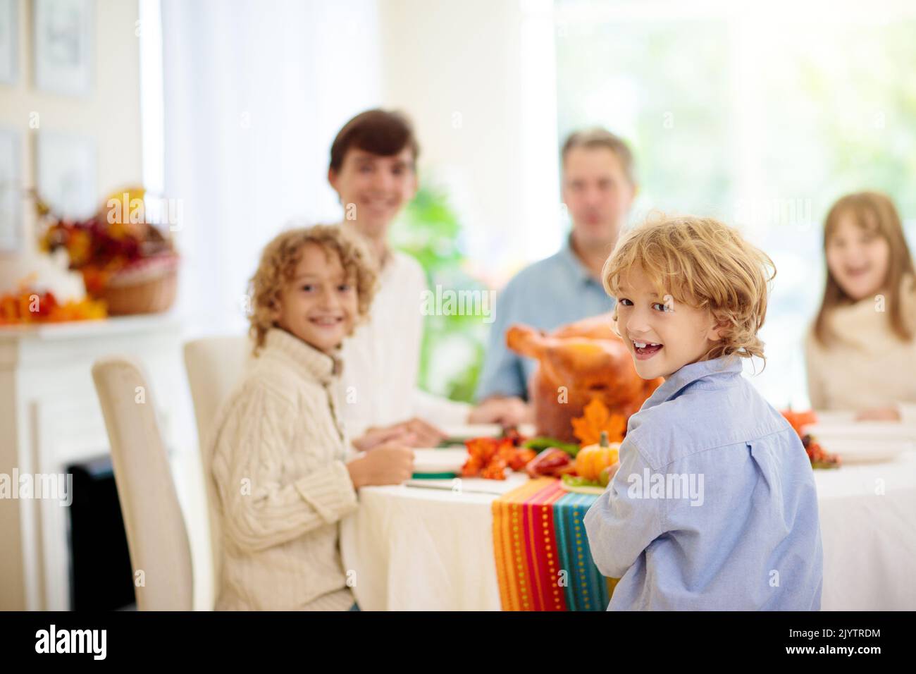 Family at Thanksgiving dinner. Parents and kids enjoy roasted turkey ...