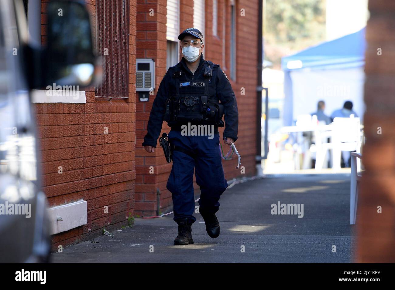A Police officer is seen at a unit block under lockdown in Campsie ...