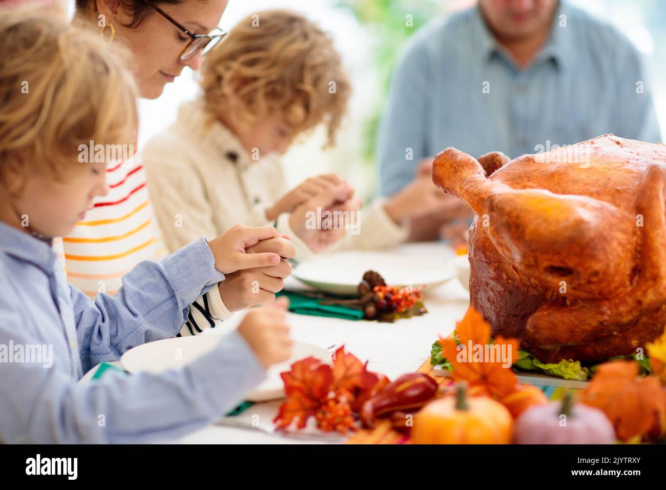 Family Thanksgiving dinner prayer. Parents and kids enjoy roasted ...