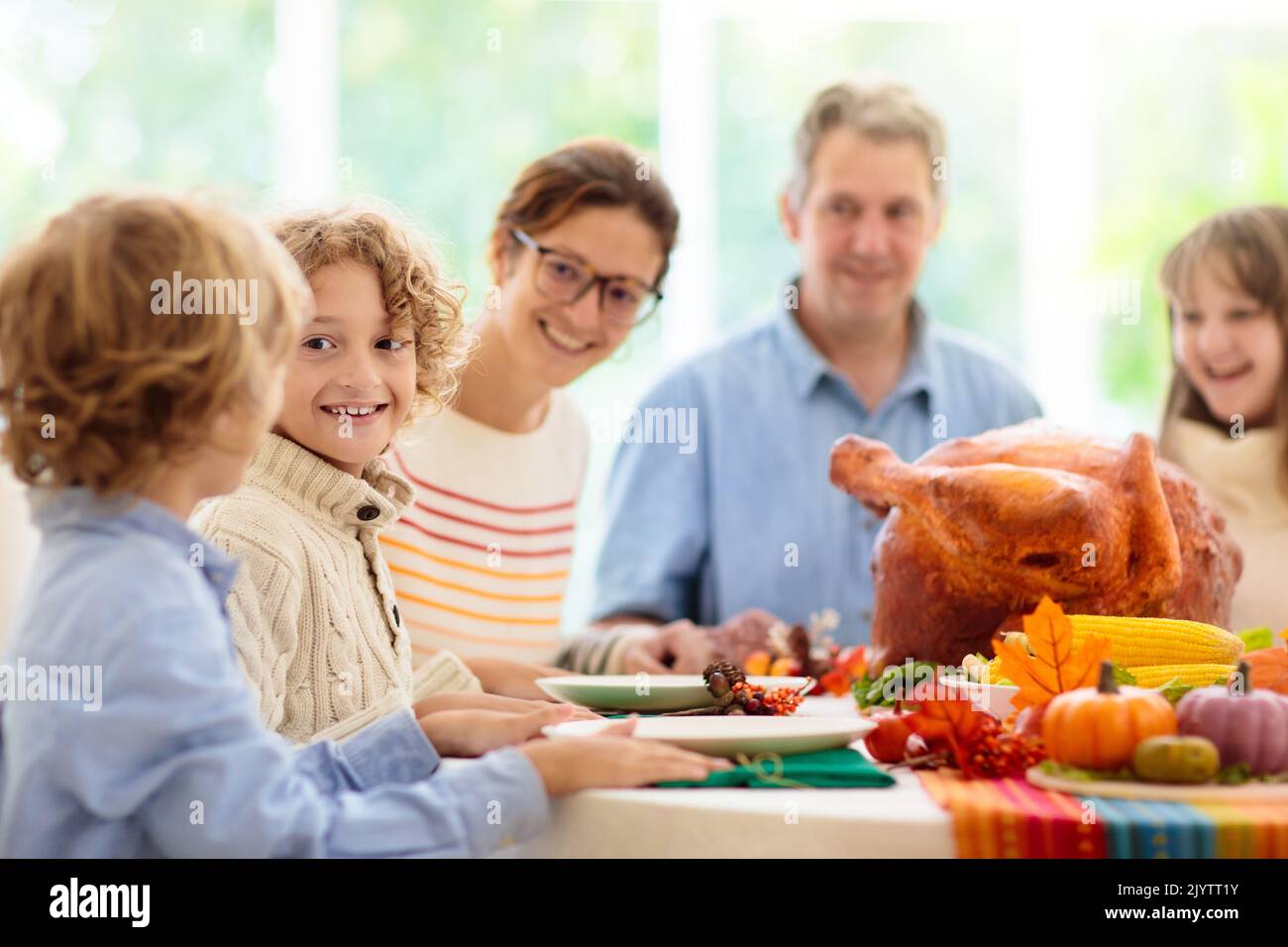 Family at Thanksgiving dinner. Parents and kids enjoy roasted turkey ...