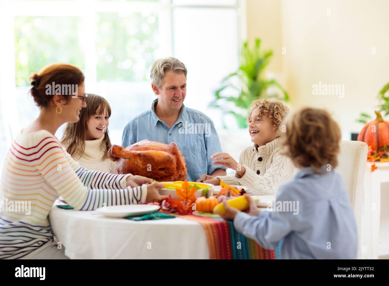 Family at Thanksgiving dinner. Parents and kids enjoy roasted turkey ...