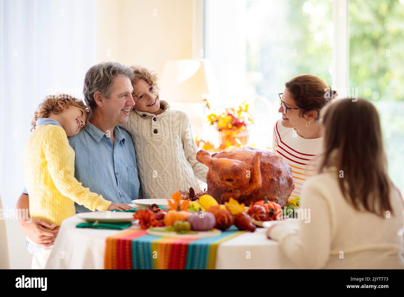 Family at Thanksgiving dinner. Parents and kids enjoy roasted turkey ...