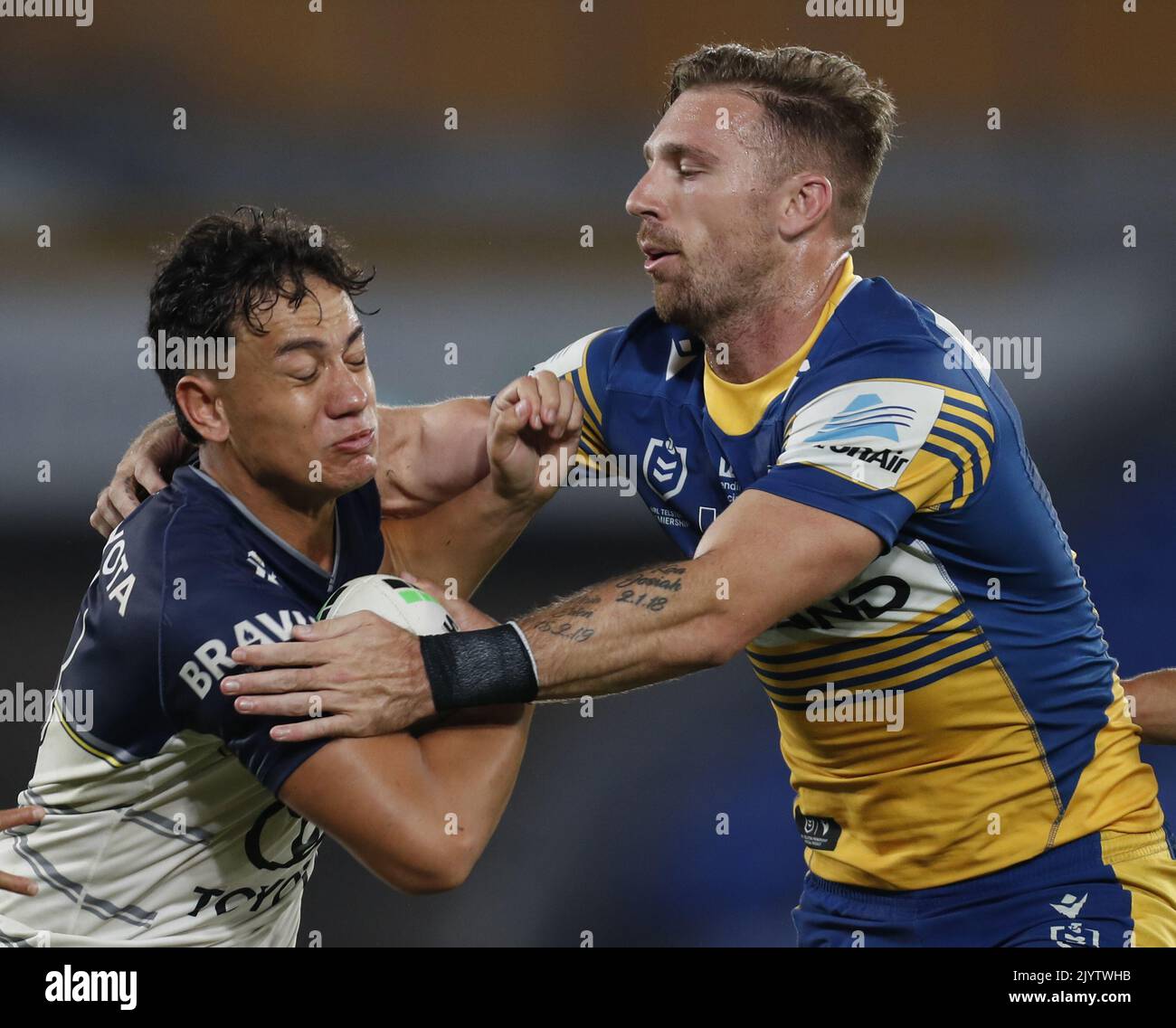 Daejarn Asi (left) of North Queensland Cowboys is tackled by Bryce ...