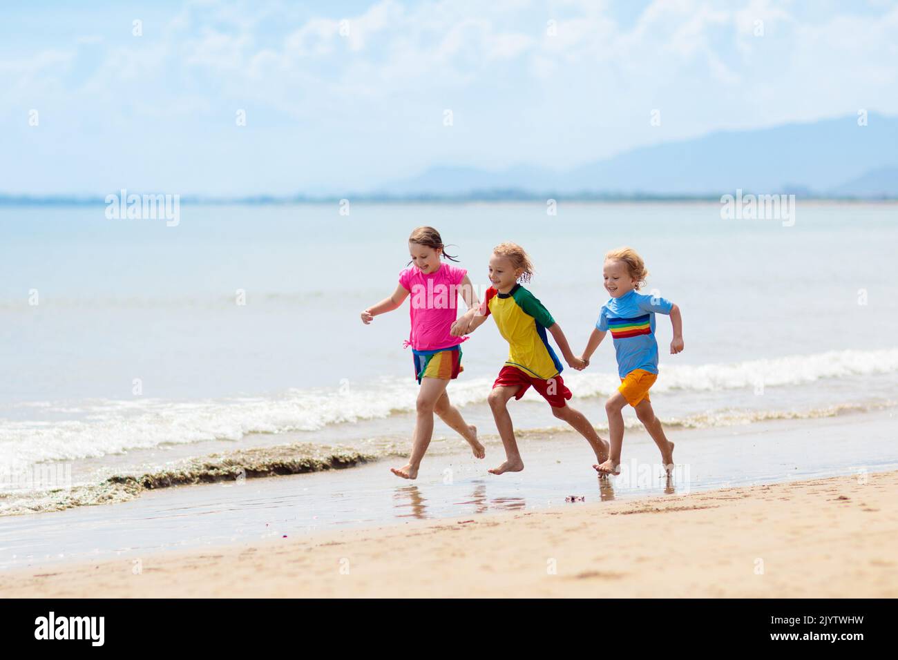 Kids playing on tropical beach. Children swim and play at sea on summer ...