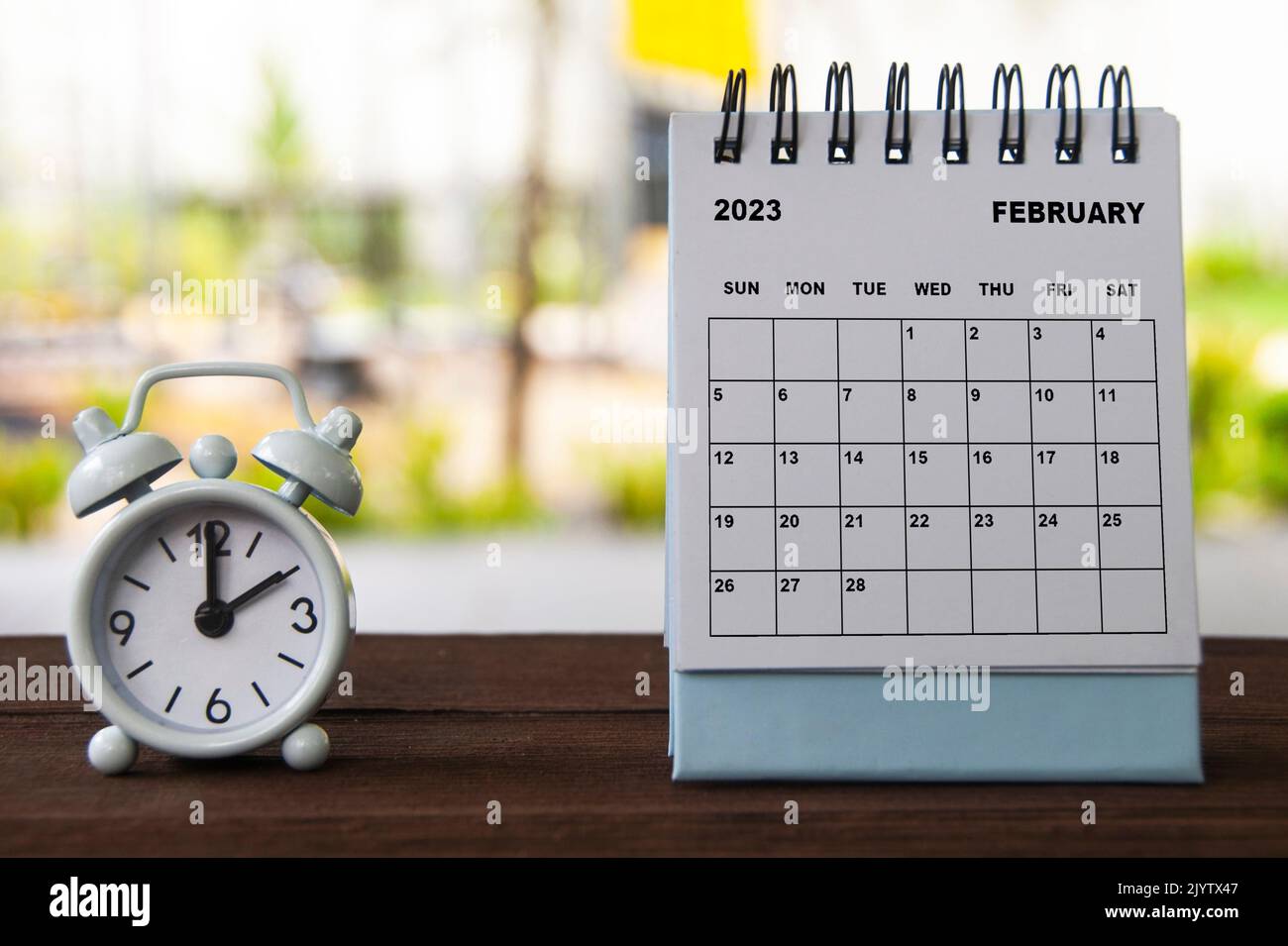 Alarm clock pointing at 2 o'clock with February 2023 on a bench. Alarm ...