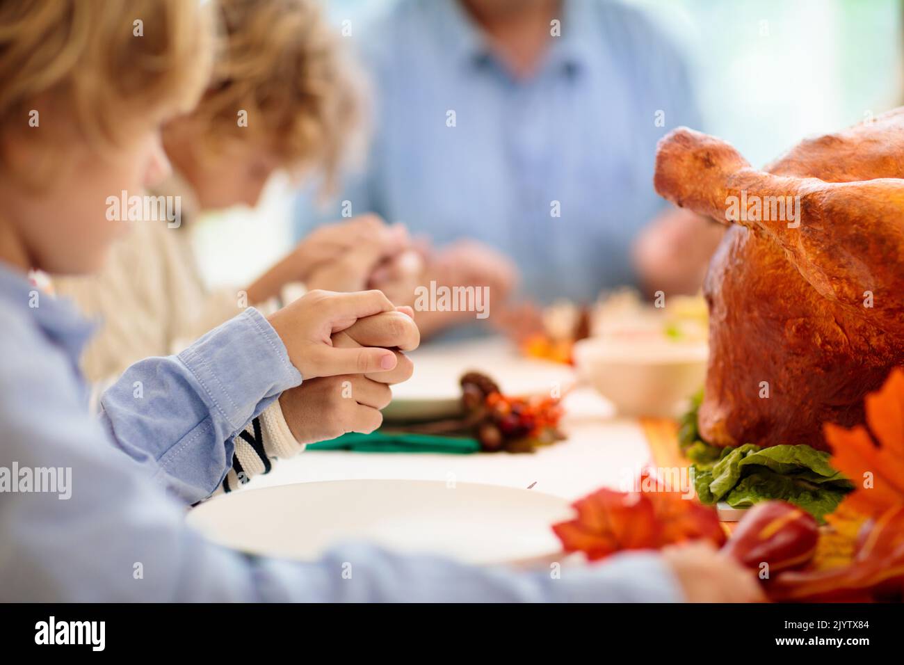 Family Thanksgiving dinner prayer. Parents and kids enjoy roasted ...