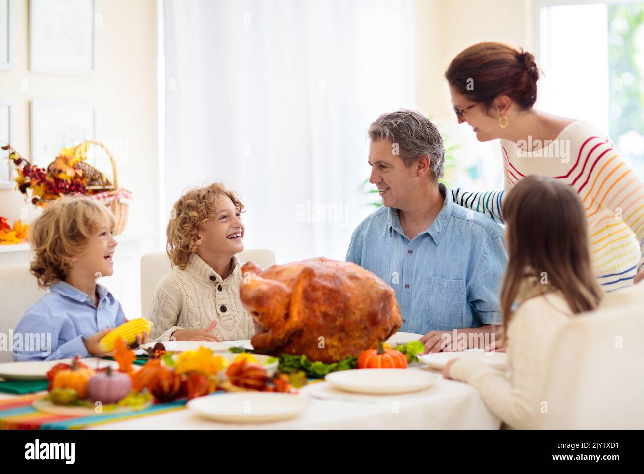 Family at Thanksgiving dinner. Parents and kids enjoy roasted turkey ...