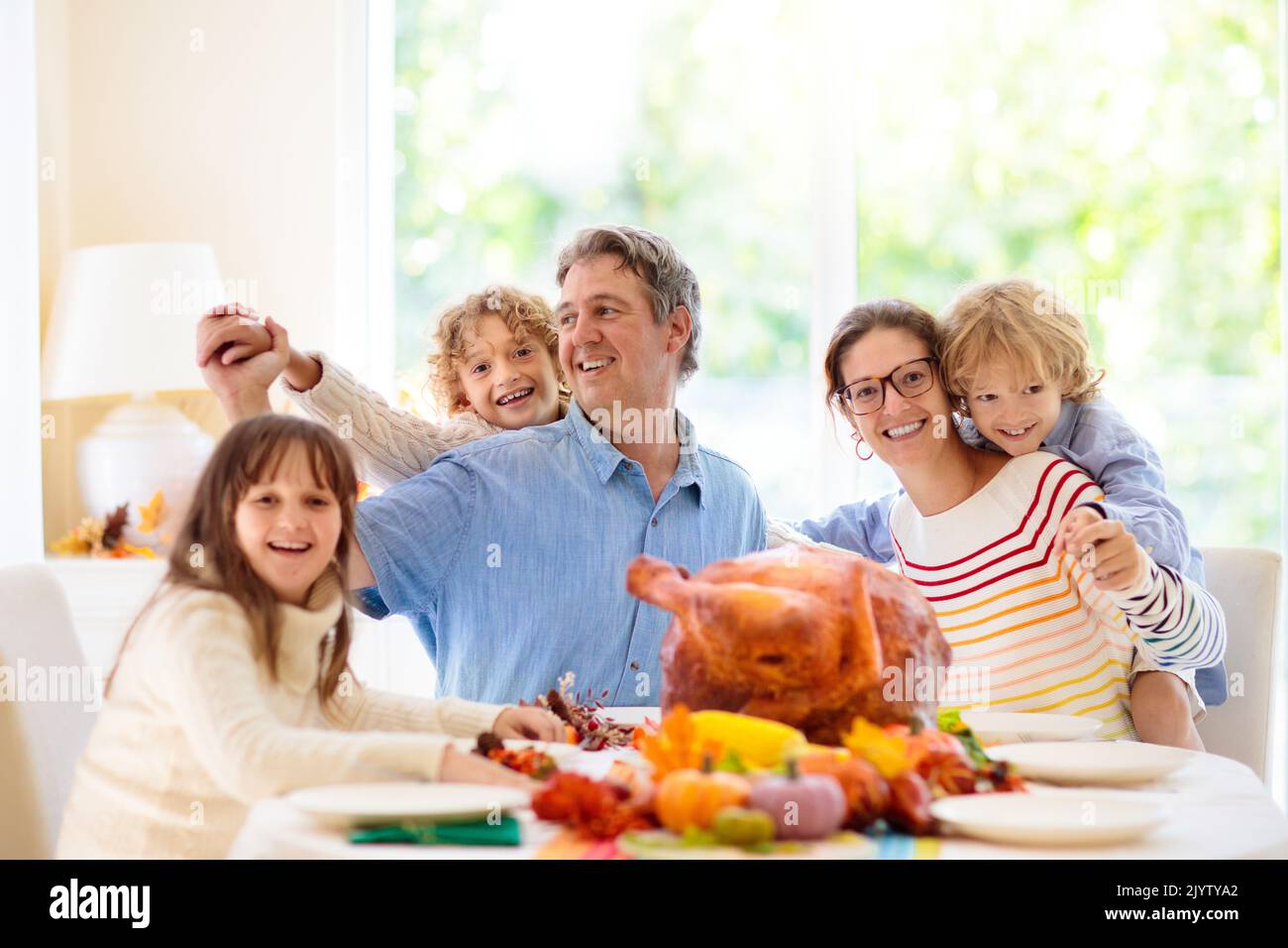 Family at Thanksgiving dinner. Parents and kids enjoy roasted turkey ...