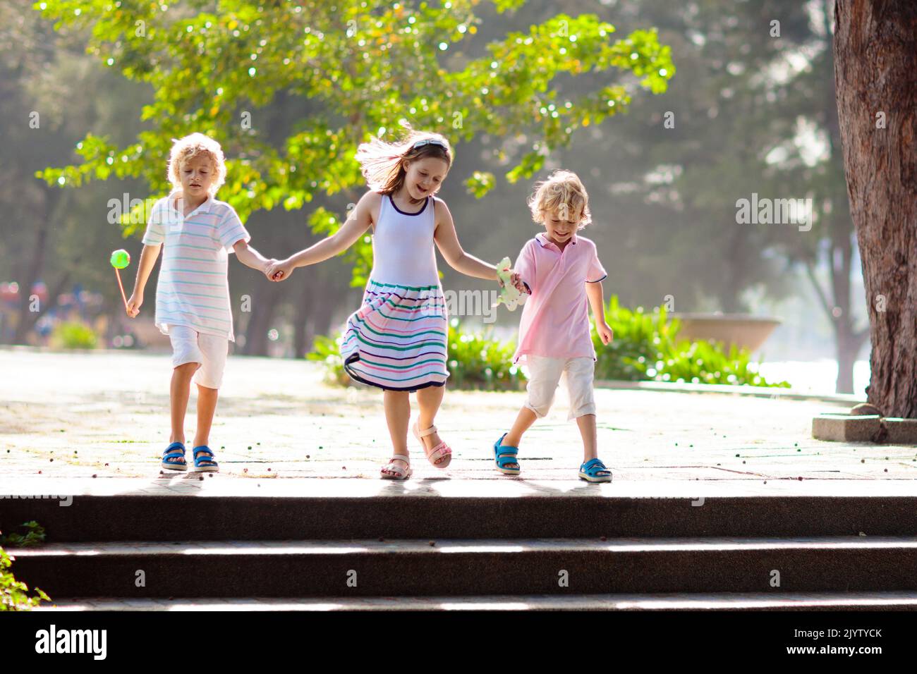 Kids in sunny summer park. Family walking holding hands. Sibling or ...