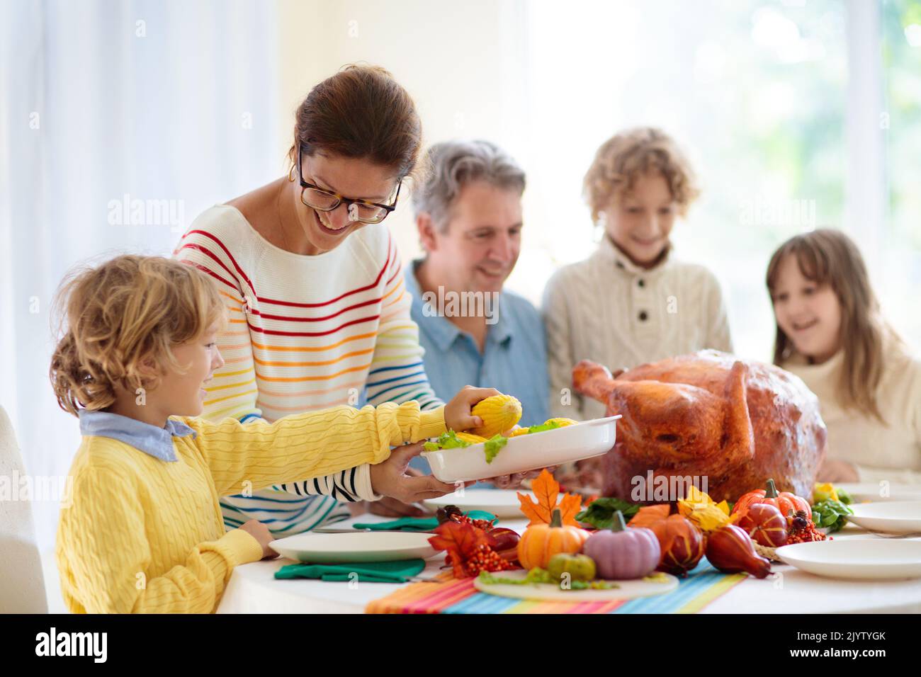 Family at Thanksgiving dinner. Parents and kids enjoy roasted turkey ...