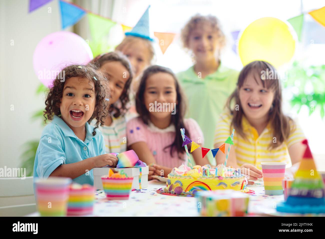 Kids birthday party. Children celebrate with colorful cake and gifts ...