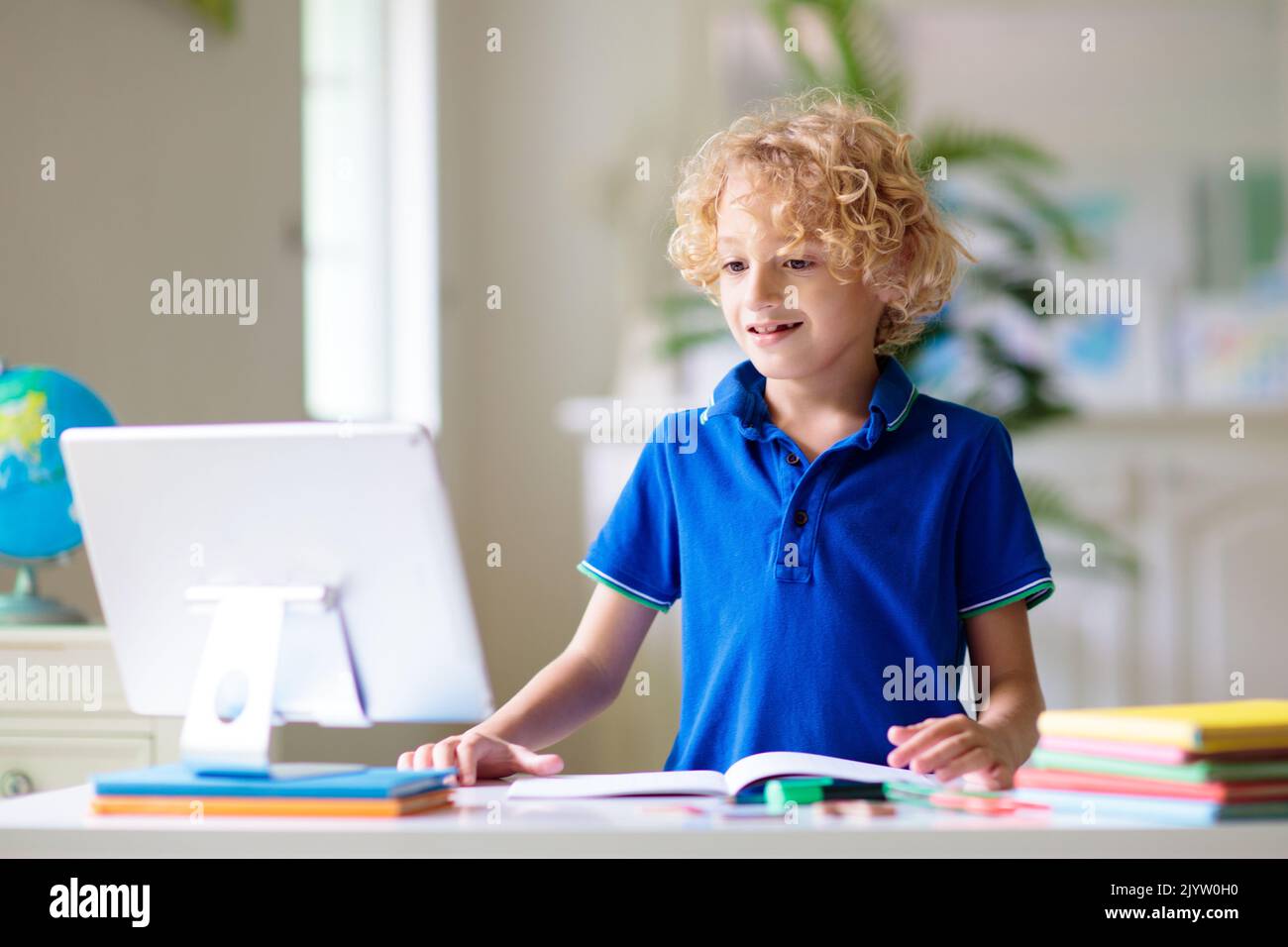 Online remote learning. School kids with computer having video ...